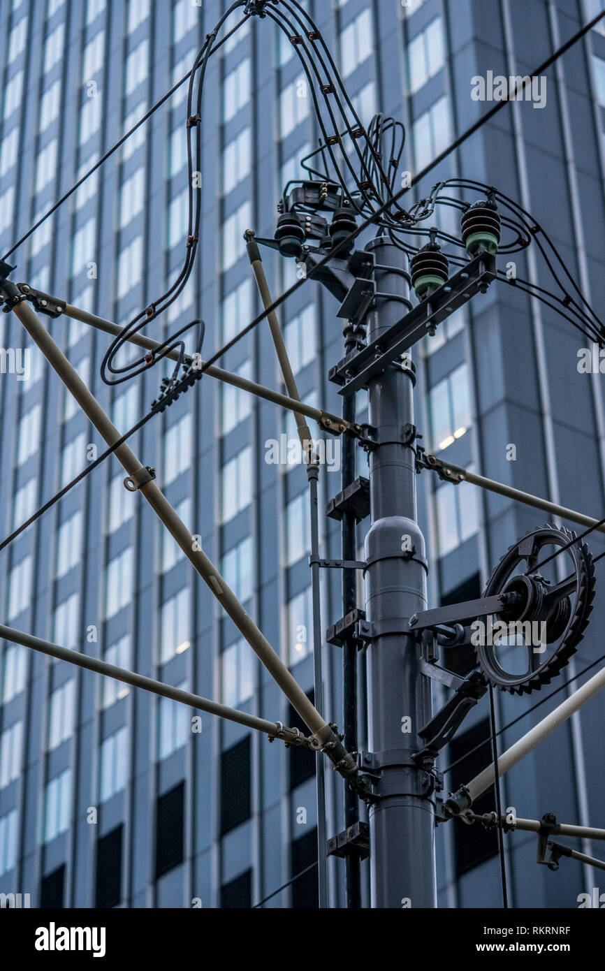 Electric rail with skyscraper in background Stock Photo - Alamy