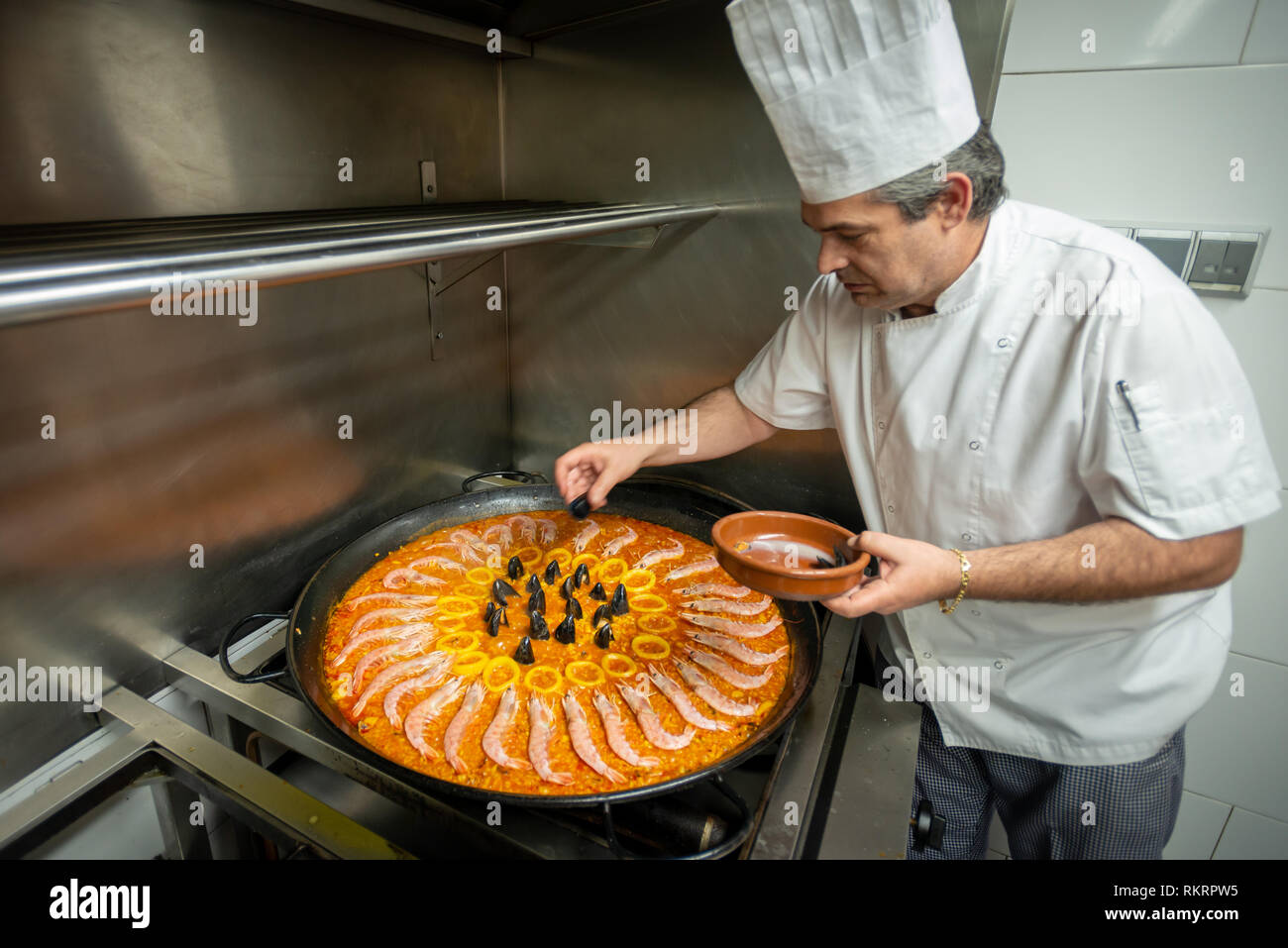 Cooking spanish paella adding seafood hi-res stock photography and ...
