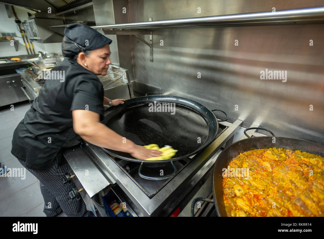 Spanish woman cooking preparing paella hi-res stock photography and ...