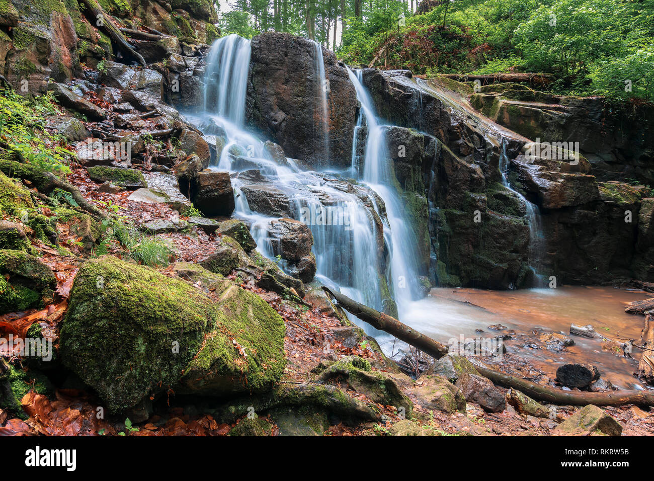 waterfall in the forest. beautiful spring scenery. water comes out of ...