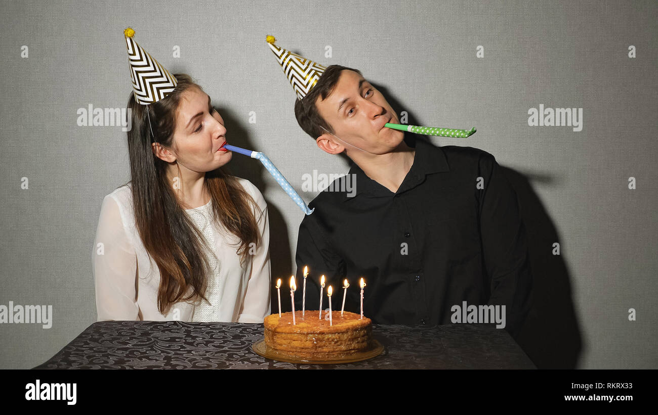 Smiling couple celebrates a holiday playing with party blowers Stock ...