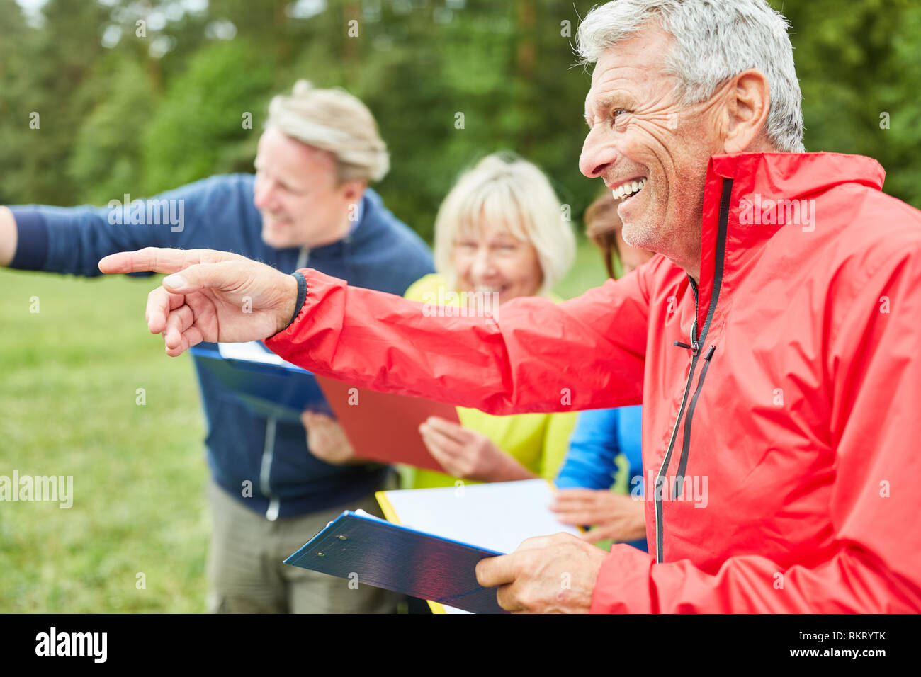Group of seniors enjoying a scavenger hunt or geocaching in nature ...