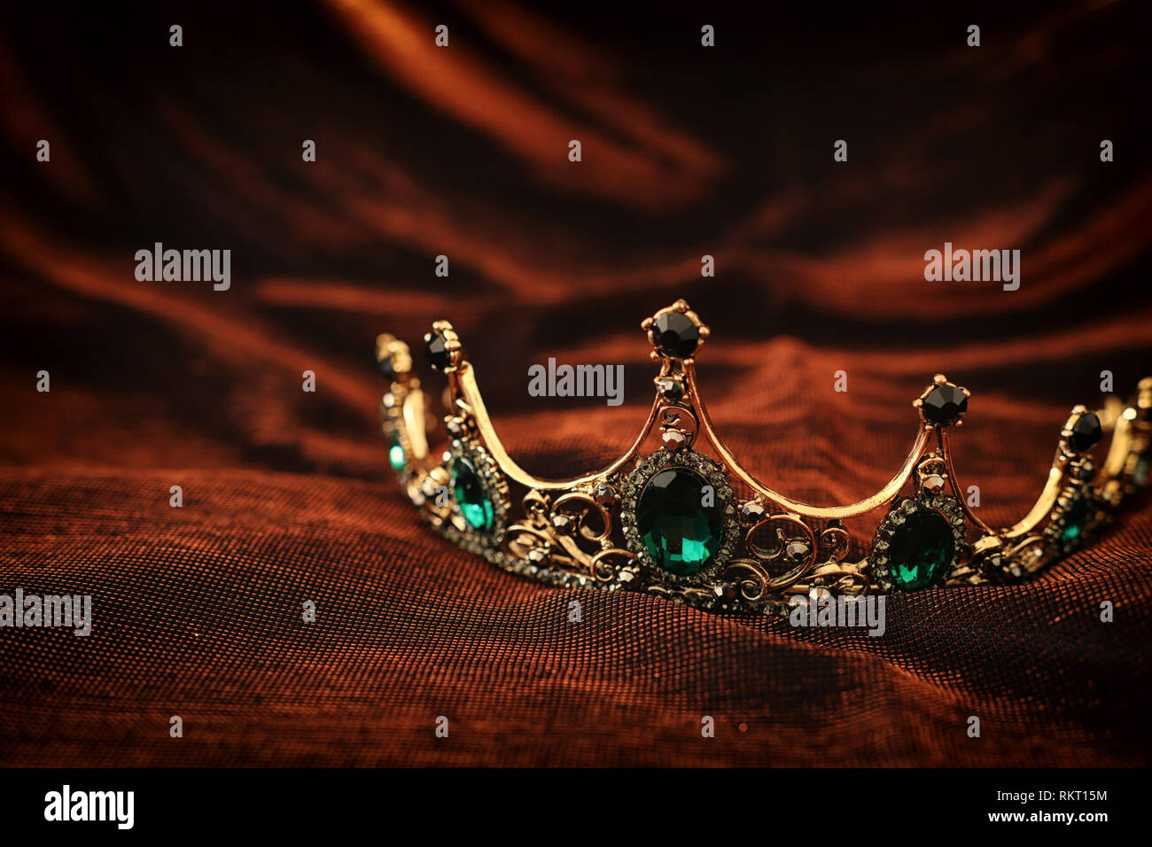 photo of gold crown over gothic dark silk background. Medieval period ...