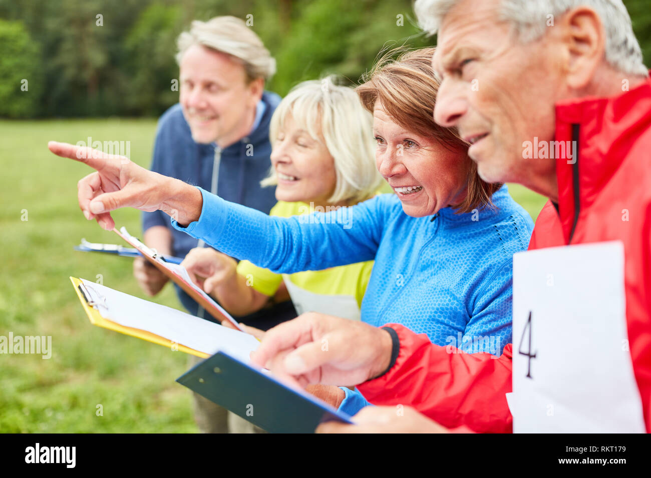 Seniors team in a scavenger hunt solves tasks in nature together Stock ...
