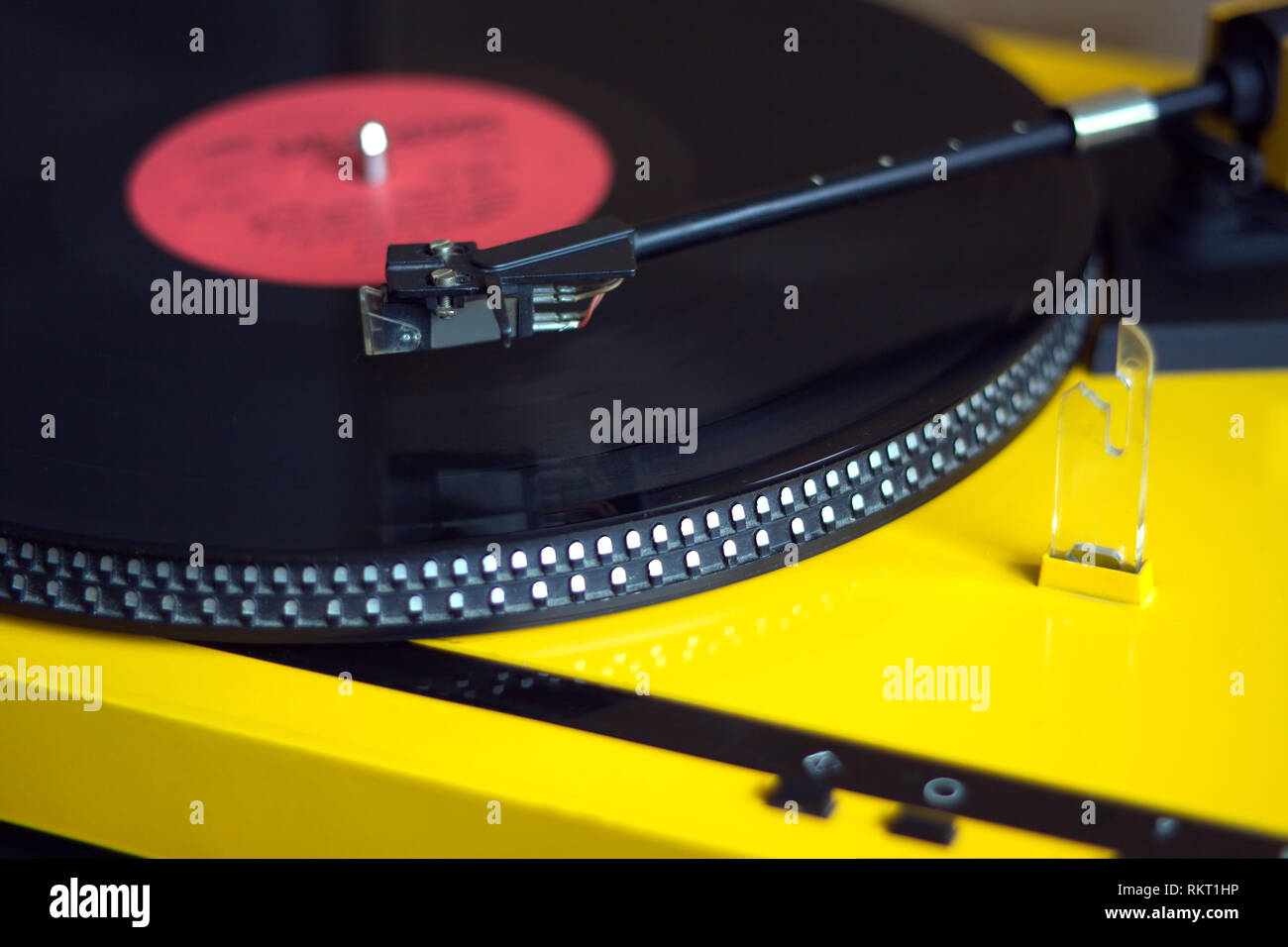Turntable in yellow case playing a vinyl record with red label side ...