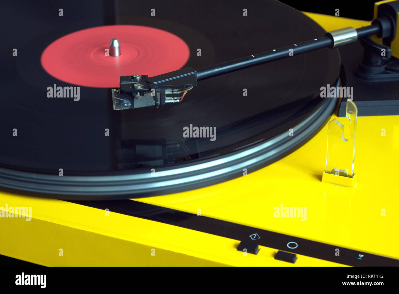 Turntable in yellow case playing a vinyl record with red label ...