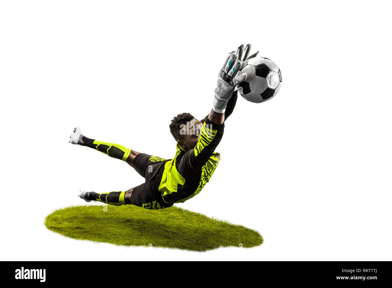 Male soccer player goalkeeper catching ball in jump. Silhouette of fit ...