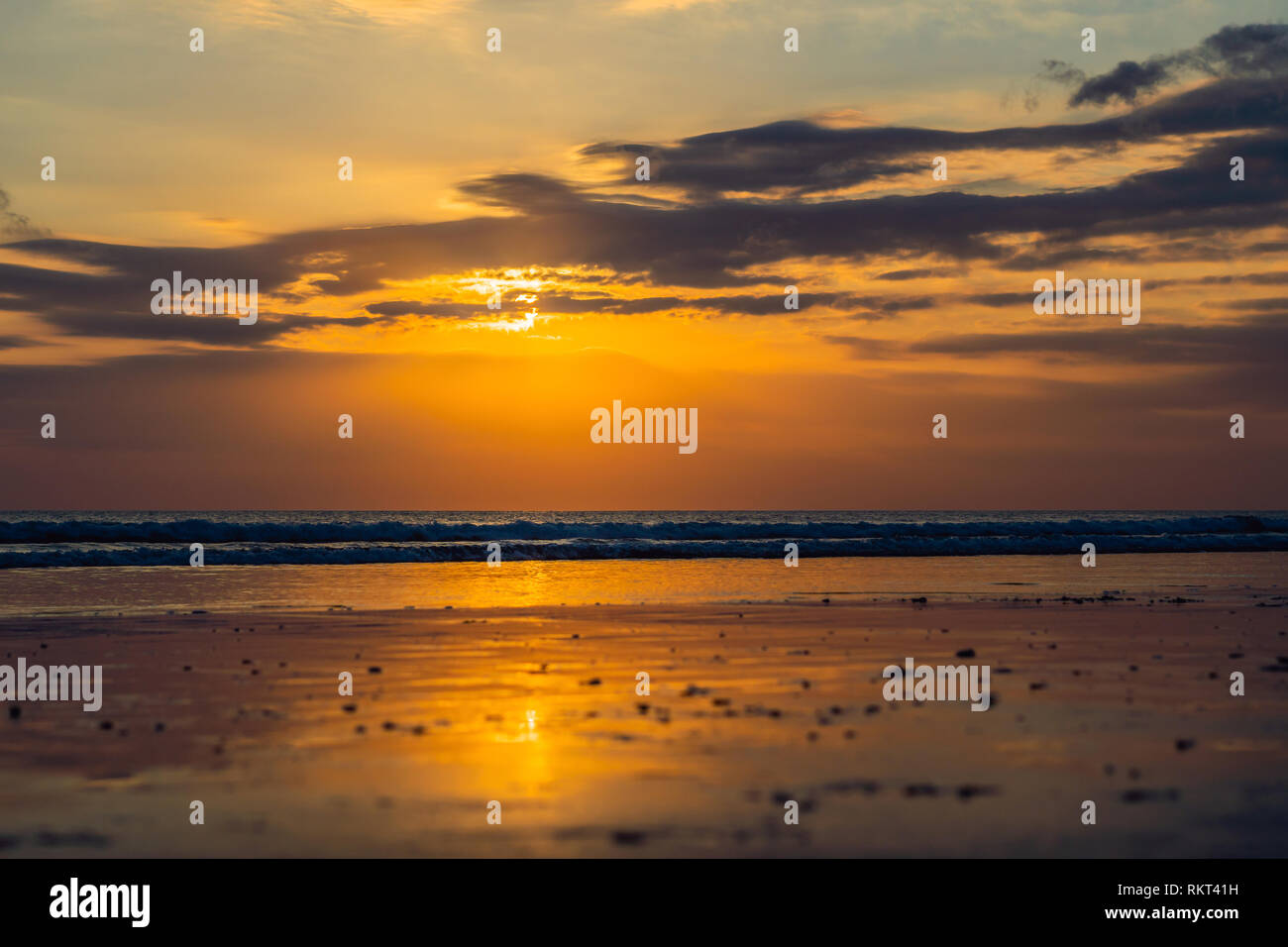 Sunset on the Kuta beach with reflection in the water on the island of ...