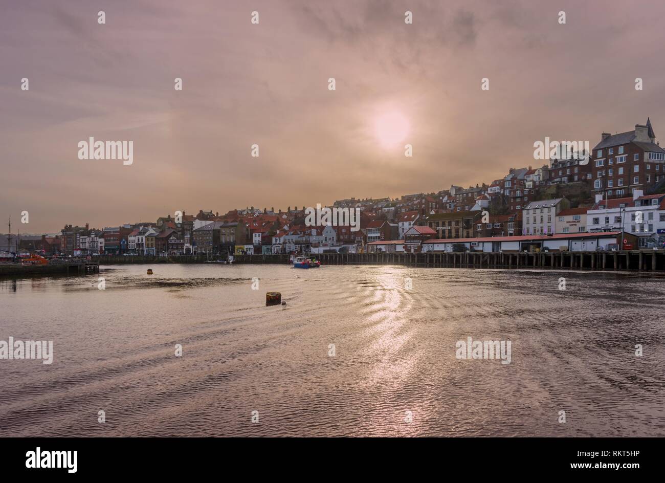 Whitby harbour looking inwards. The town’s buildings stack upwards next ...