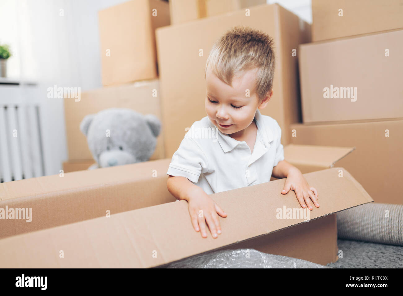 Cute toddler helping out packing boxes and moving Stock Photo - Alamy