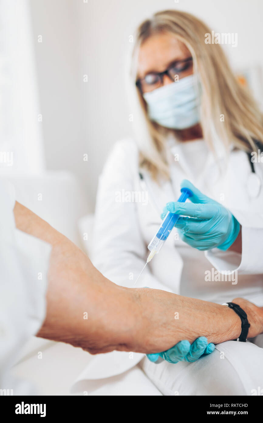Doctor administering injection hi-res stock photography and images - Alamy