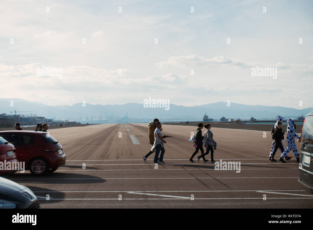 Pedestrians walk across the runway at the famous Gibraltar Airport ...