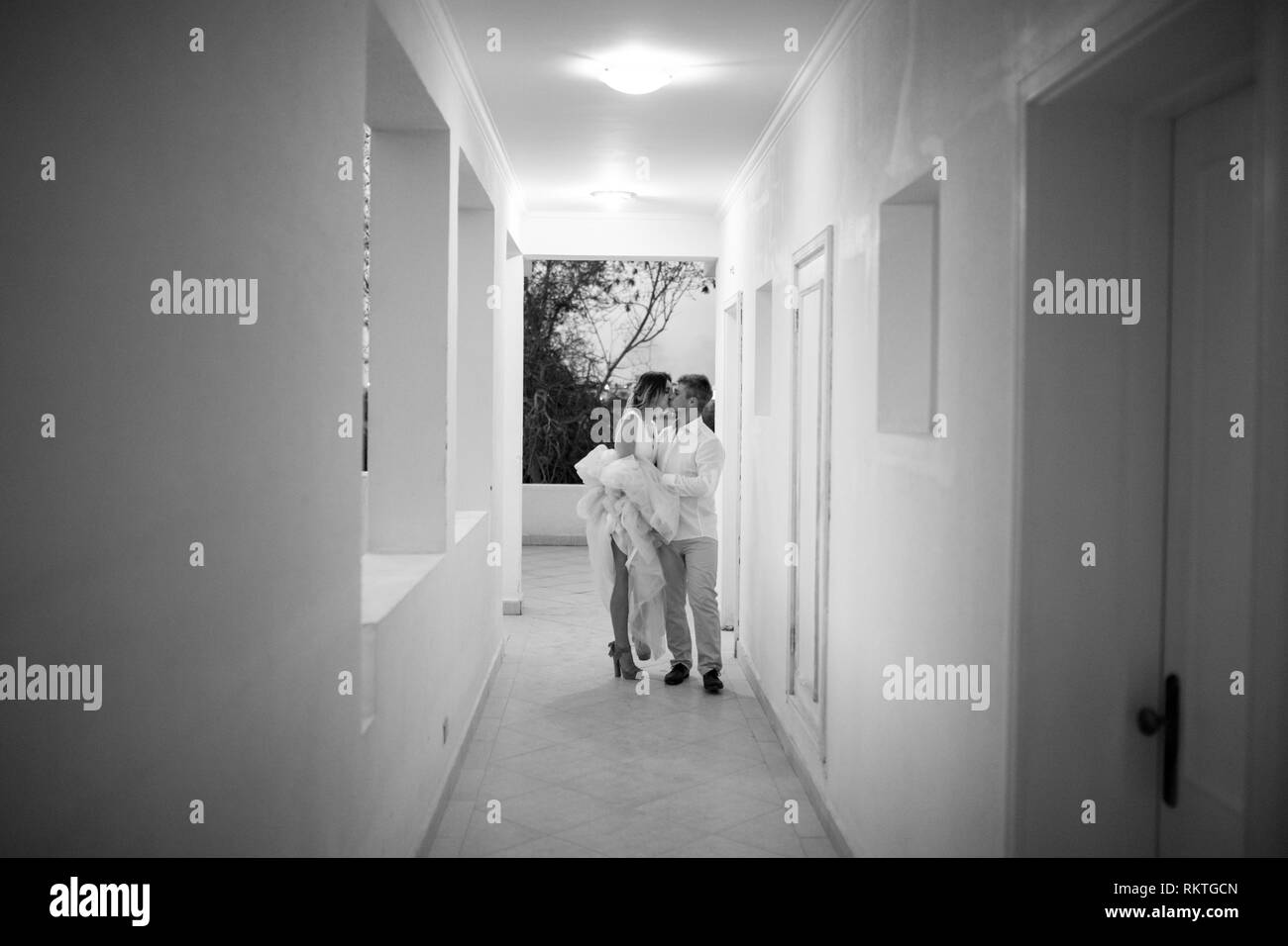 Happy newlyweds kiss on terrace of house in the evening during the ...