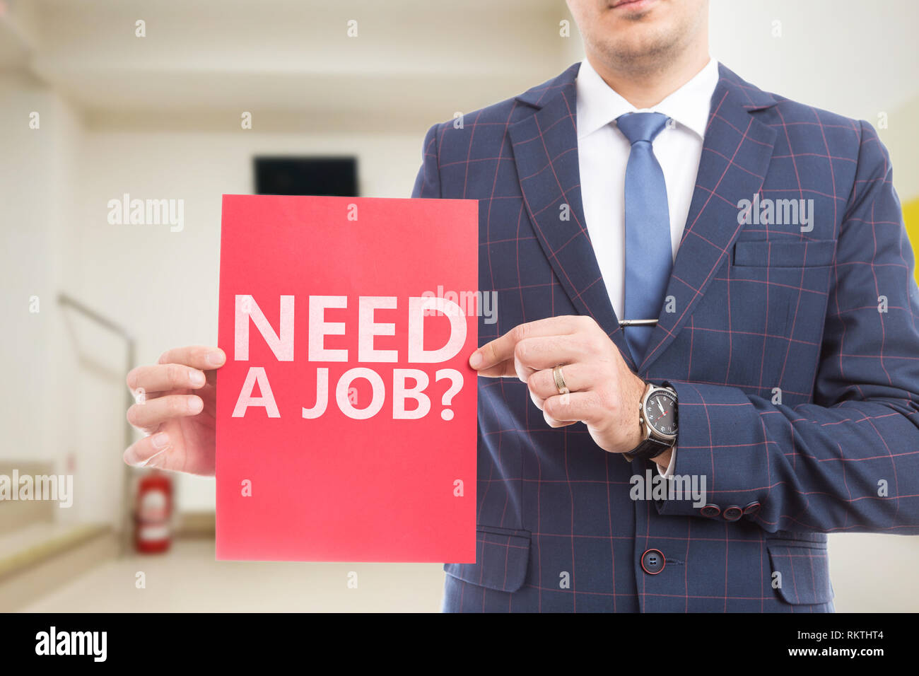 Businessman showing need a job question on red paper as advertising ...