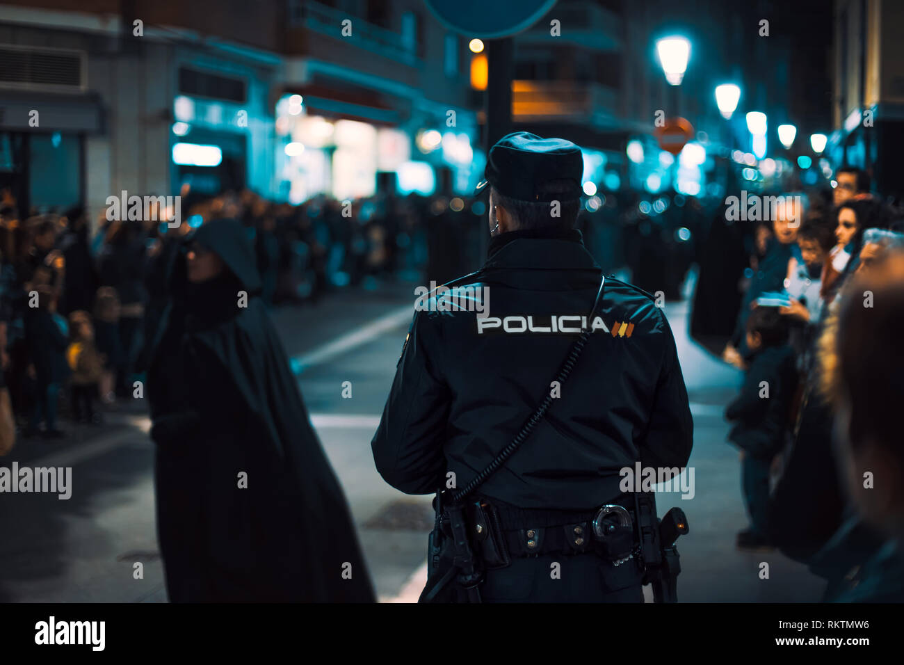 Rear view of Police officer watching during crowded religious event ...