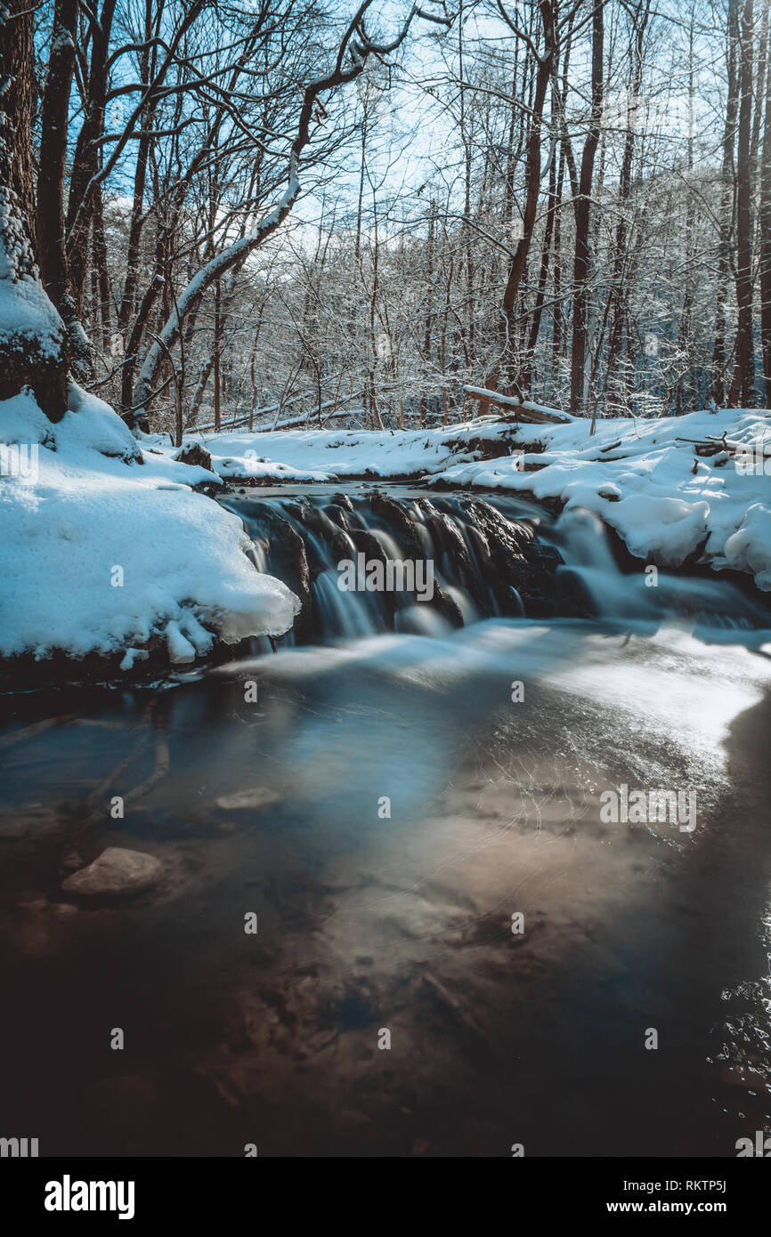 A long exposure photo of a small waterfall during the winter Stock ...