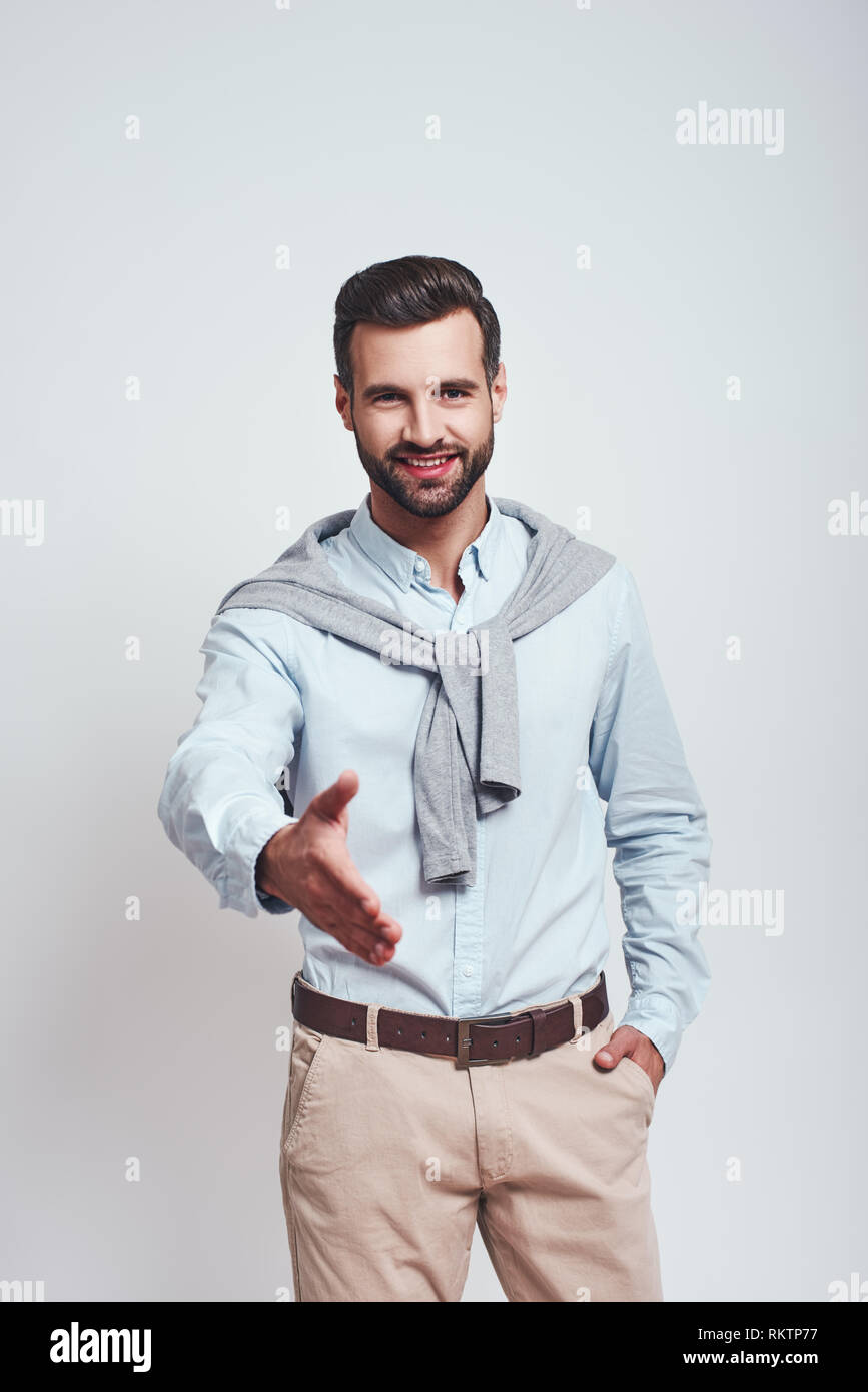Hello. My name is...Cute smiling man is extending hand to shake while ...