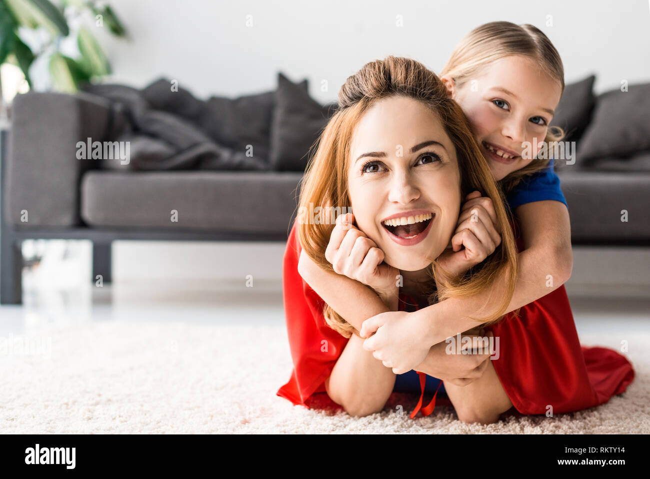 Cute kid and attractive mother hugging on floor Stock Photo - Alamy