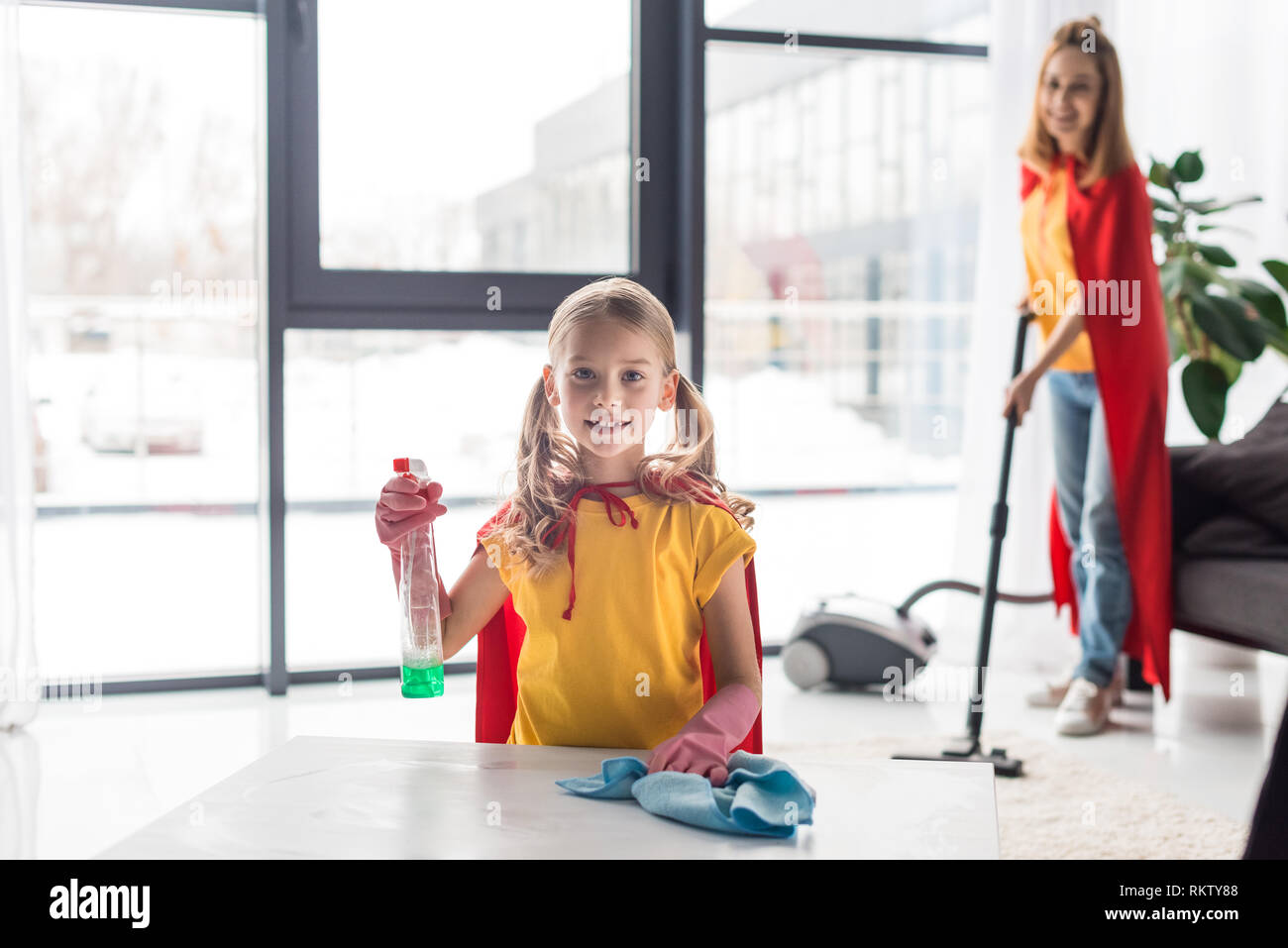 Cute kid dusting and mother with vacuum cleaner at home Stock Photo - Alamy