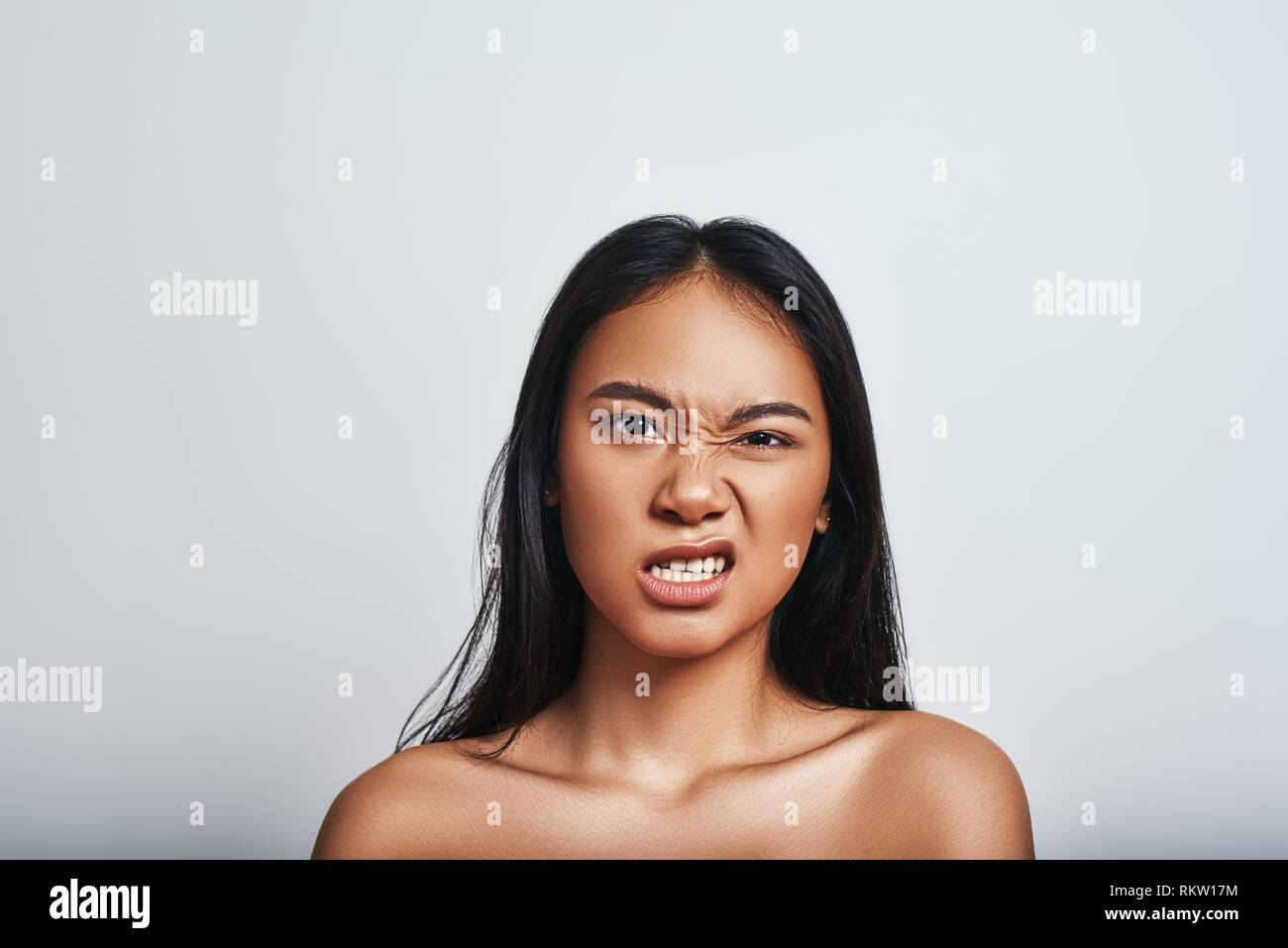 Disgust. Displeased asian woman with long hair making a face and ...