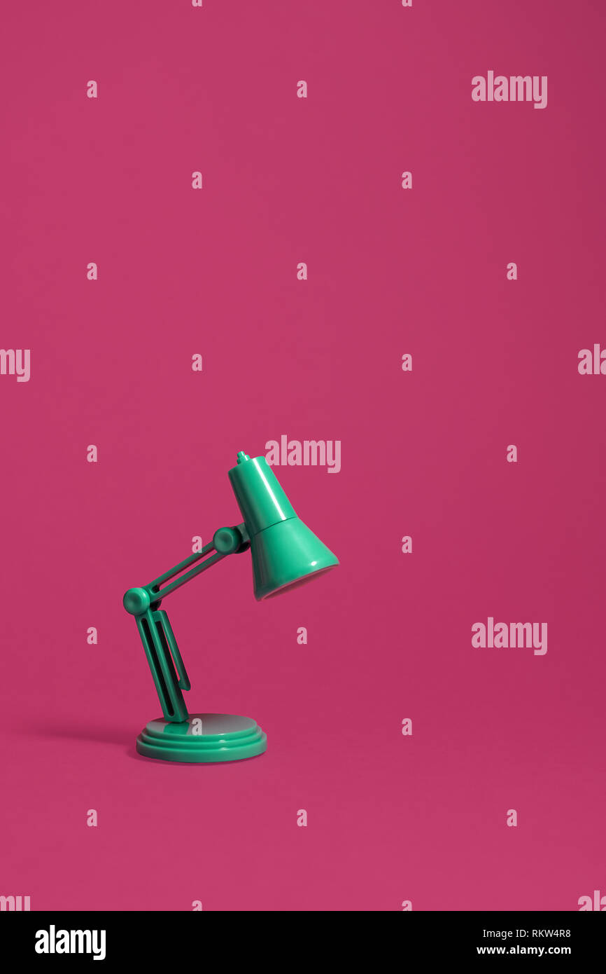 Vintage green desk lamp turned off on a bright pink background work ...