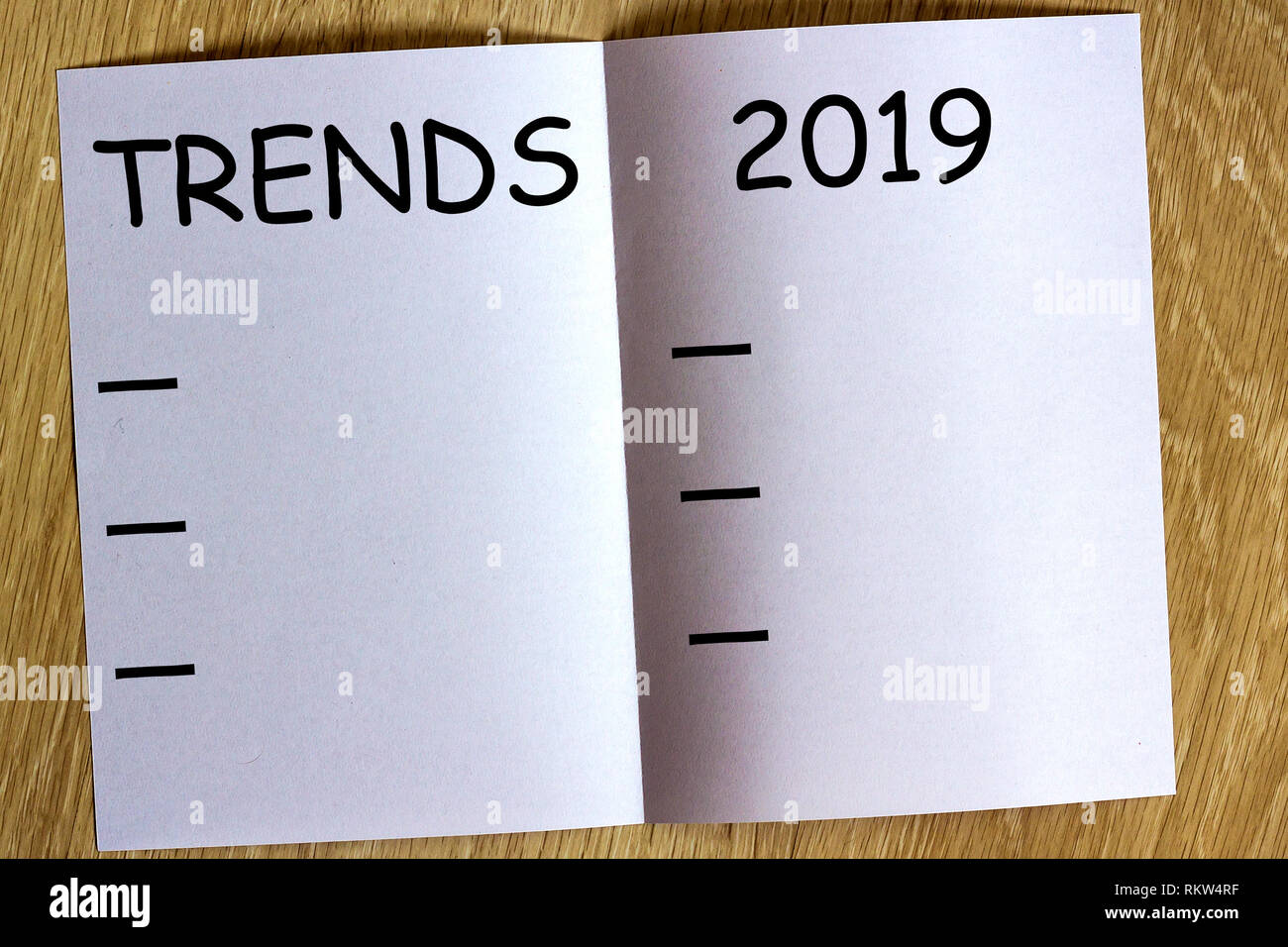 White sheen of paper on wooden background with text "Trends 2019" on it ...