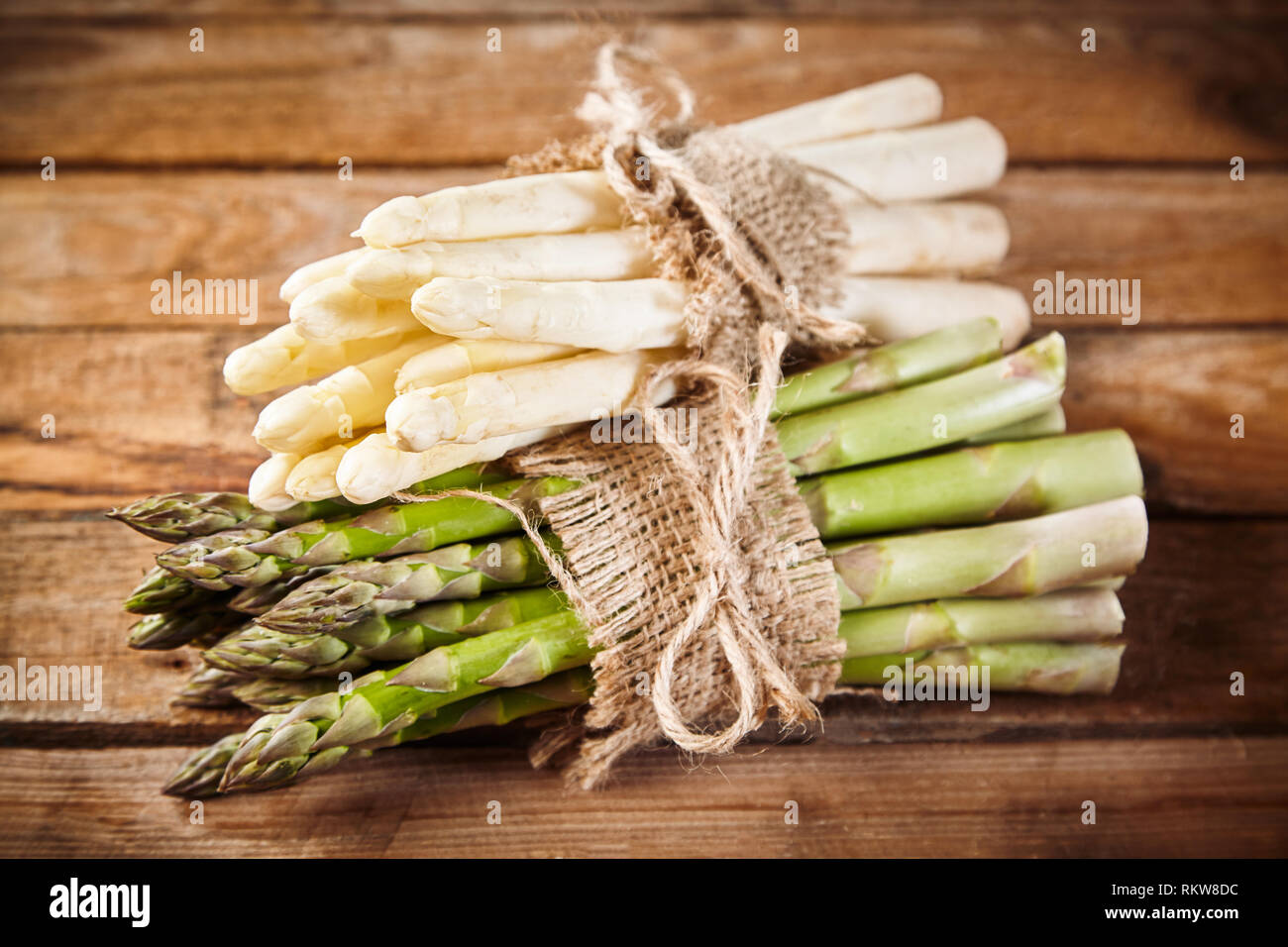 Spring harvest of fresh green and white asparagus spears tied with ...