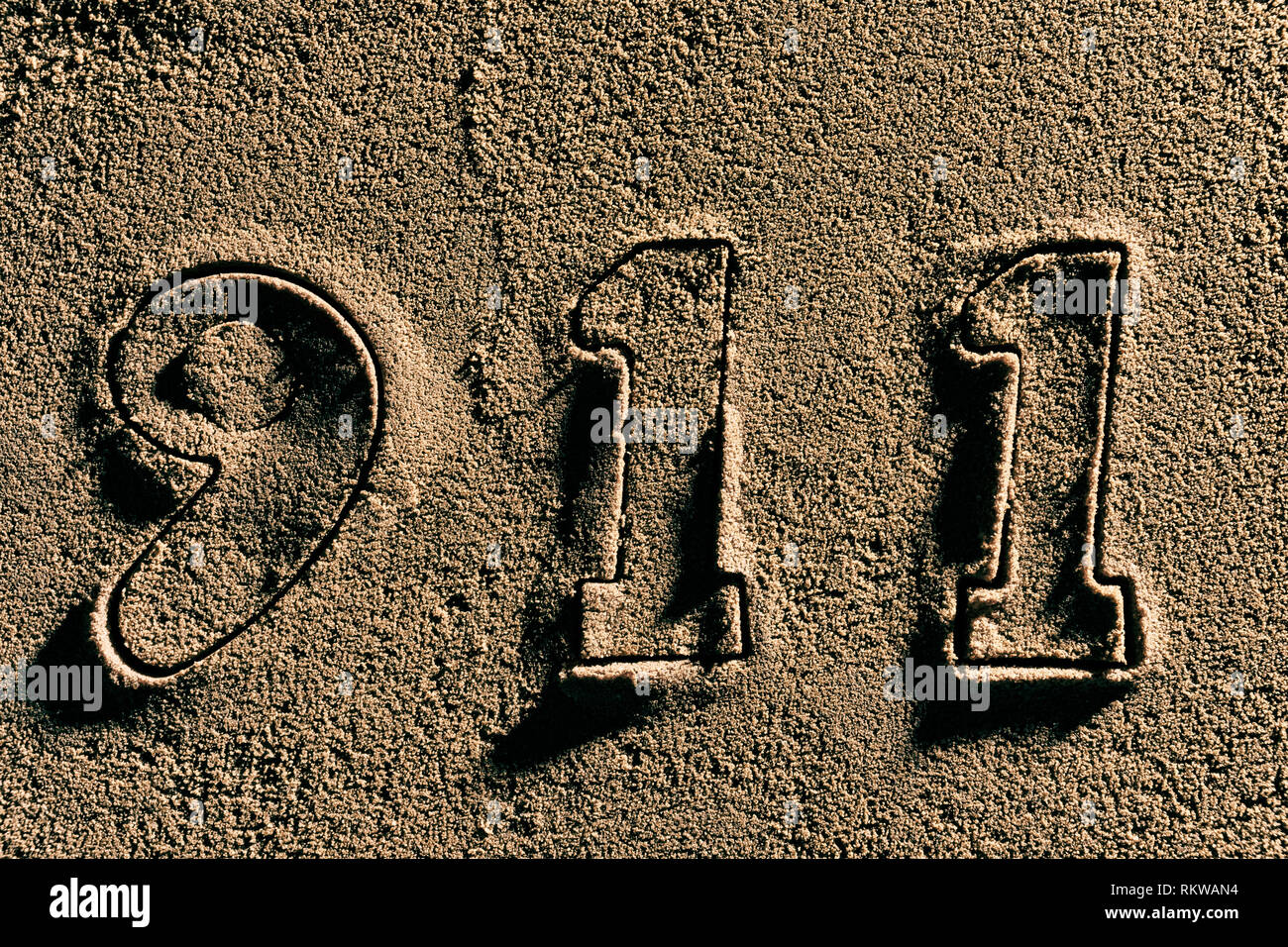 The numbers 911 cut into wet sand Stock Photo - Alamy