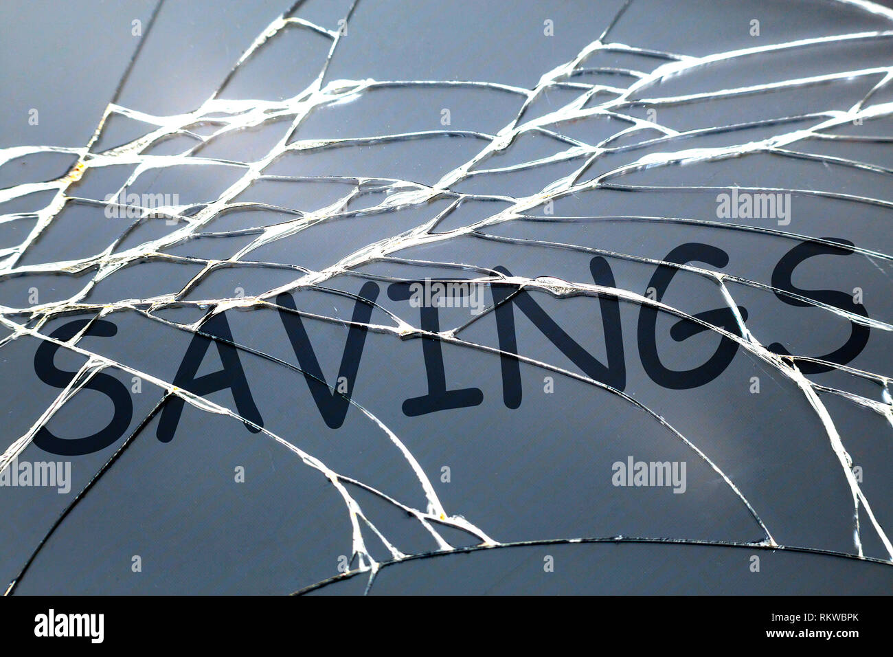 Broken cracked glass with word "Savings" on it Stock Photo - Alamy