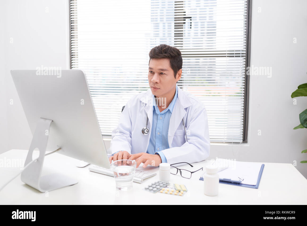 Portrait of senior doctor sitting in medical office Stock Photo - Alamy