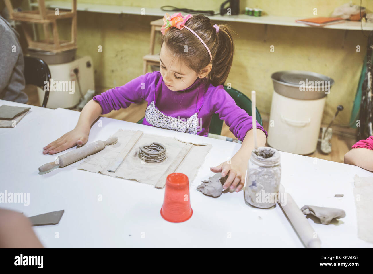 Child pottery workshop, little girl working with clay, creative ...