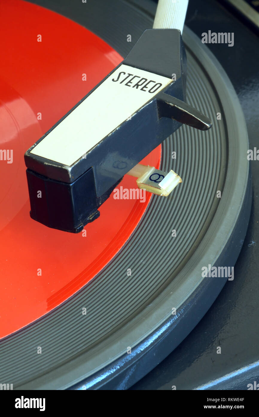 Old vintage record player playing red flexible disc. Vertical top view ...