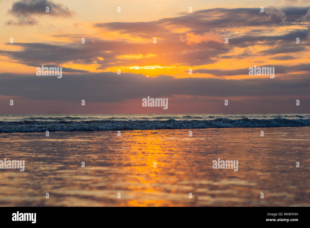 Sunset on the Kuta beach with reflection in the water on the island of ...