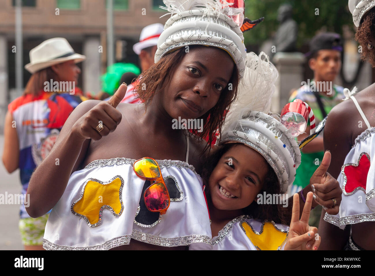 Mother and daughter giving a thumbs up in festive costumes at a ...