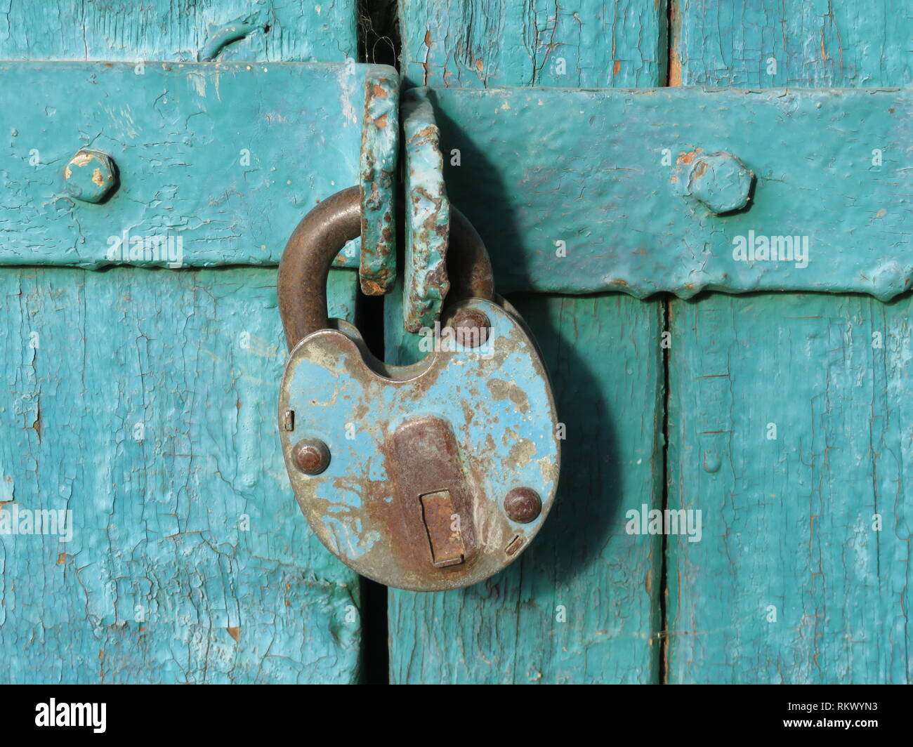 Old rusty padlock on green wooden doors. Locked gates, home security ...