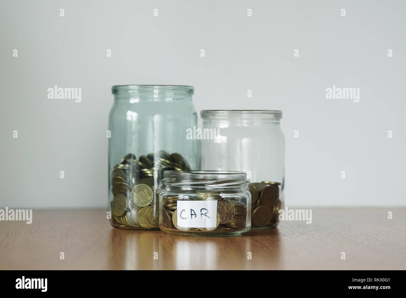 Coins in glass jars for different needs, money boxes. Distribution of ...