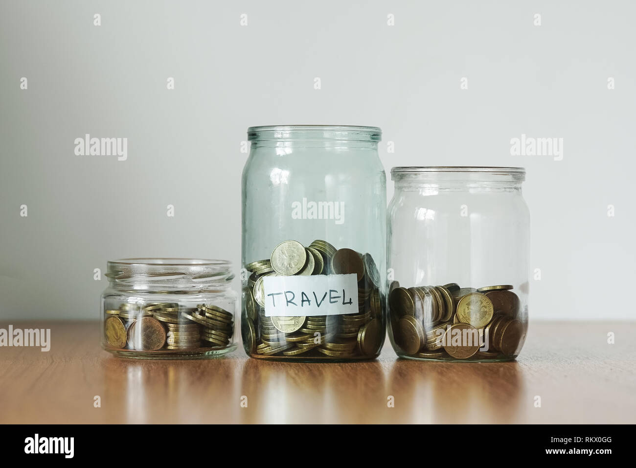 Coins in glass jars for different needs, money boxes. Distribution of ...