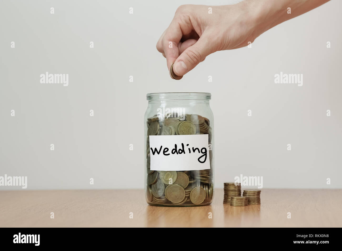Distribution of cash savings concept. Hand puts coins to the glass ...