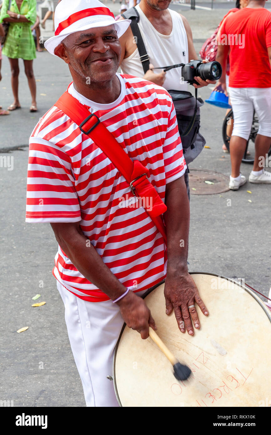 Samba drummer with a hat on at a carnival block party in the city ...