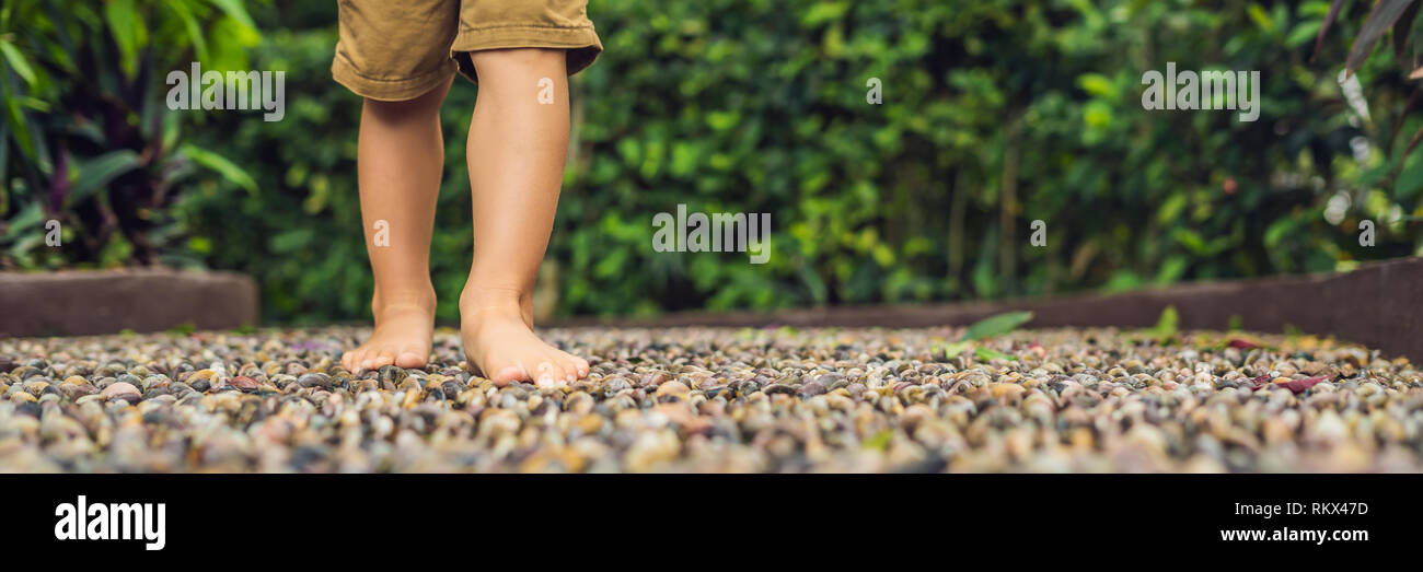 Boy Walking On A Textured Cobble Pavement, Reflexology. Pebble stones ...