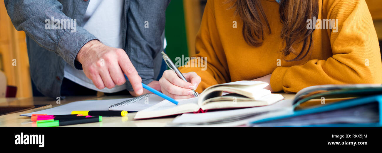 Young teacher helping his student in chemistry class. Education ...