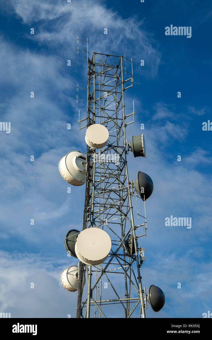 Radio communcations tower isolated against a blue sky with clouds Stock ...