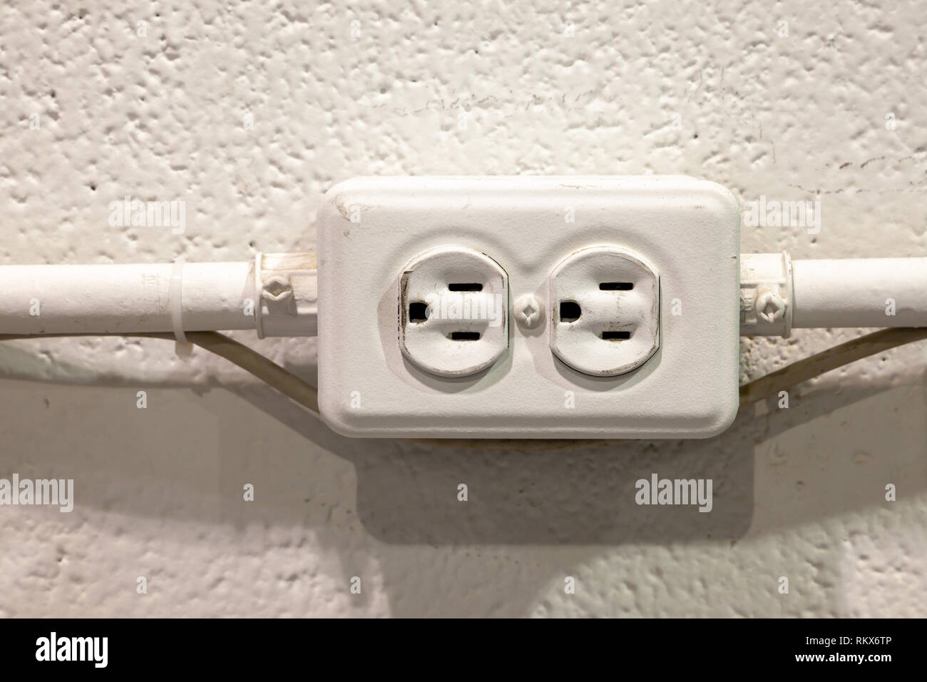 Old rustic North American electrical outlet on a white brick wall Stock ...