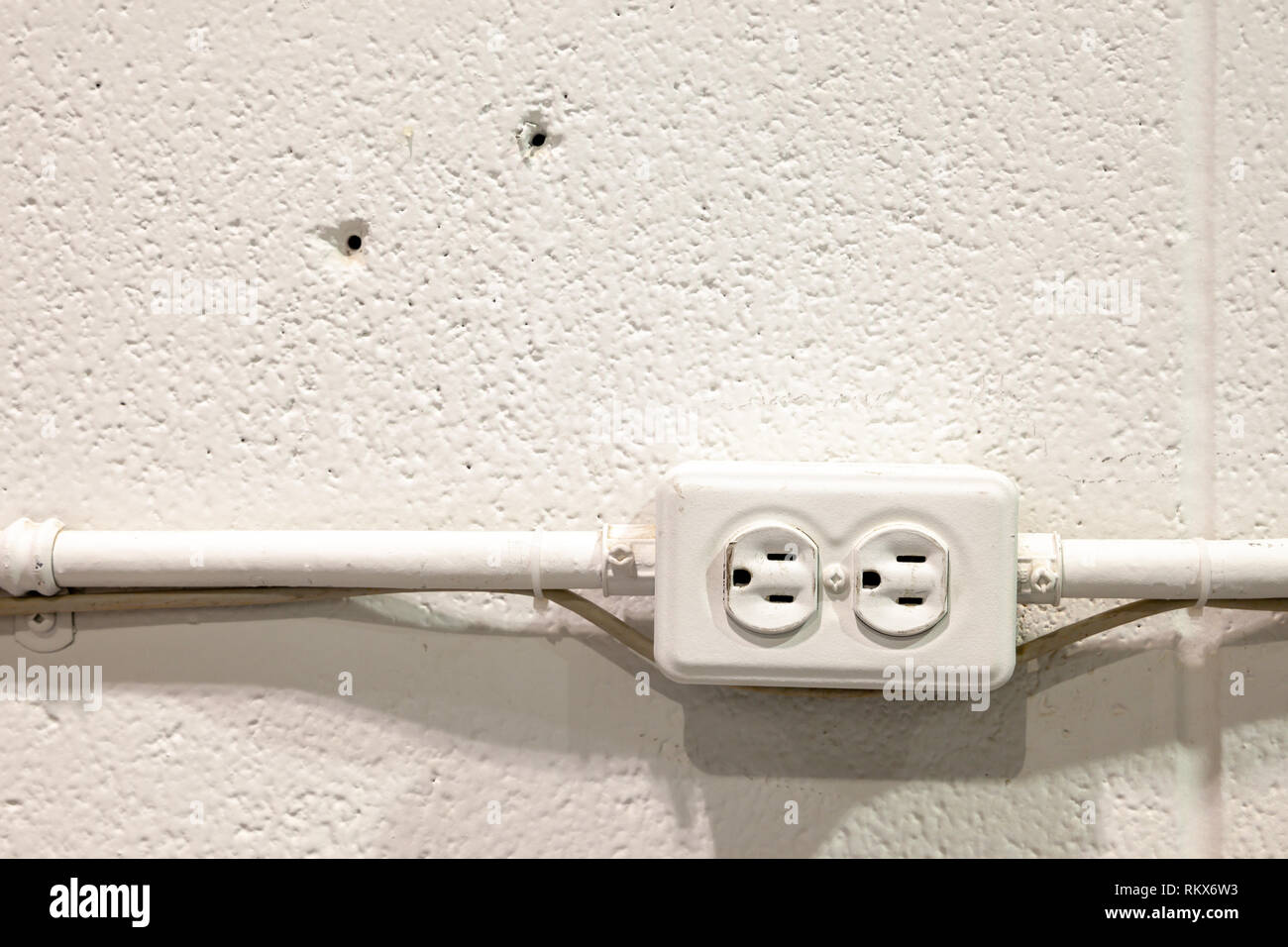 Old rustic North American electrical outlet on a white brick wall Stock ...