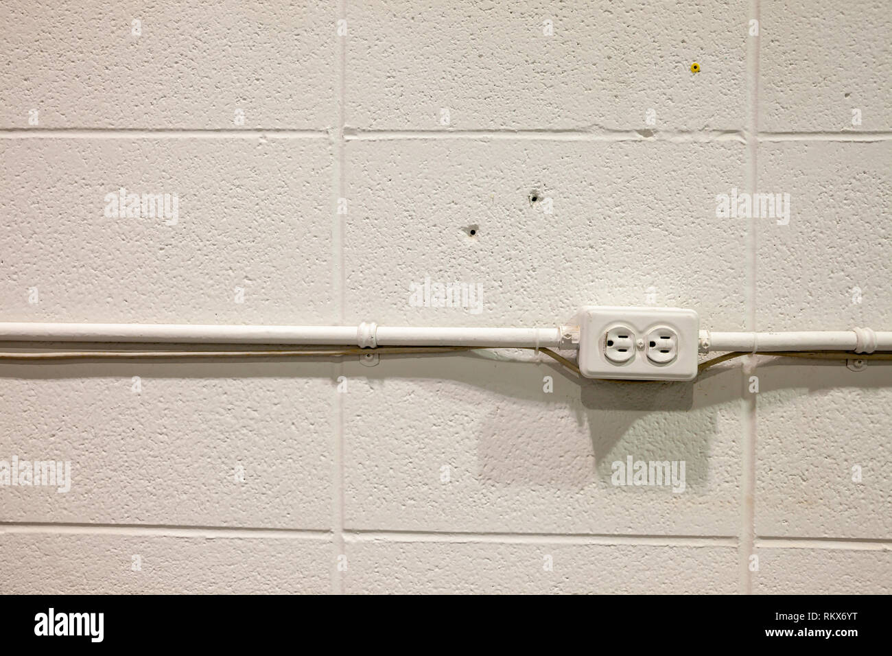 Old rustic North American electrical outlet on a white brick wall Stock ...