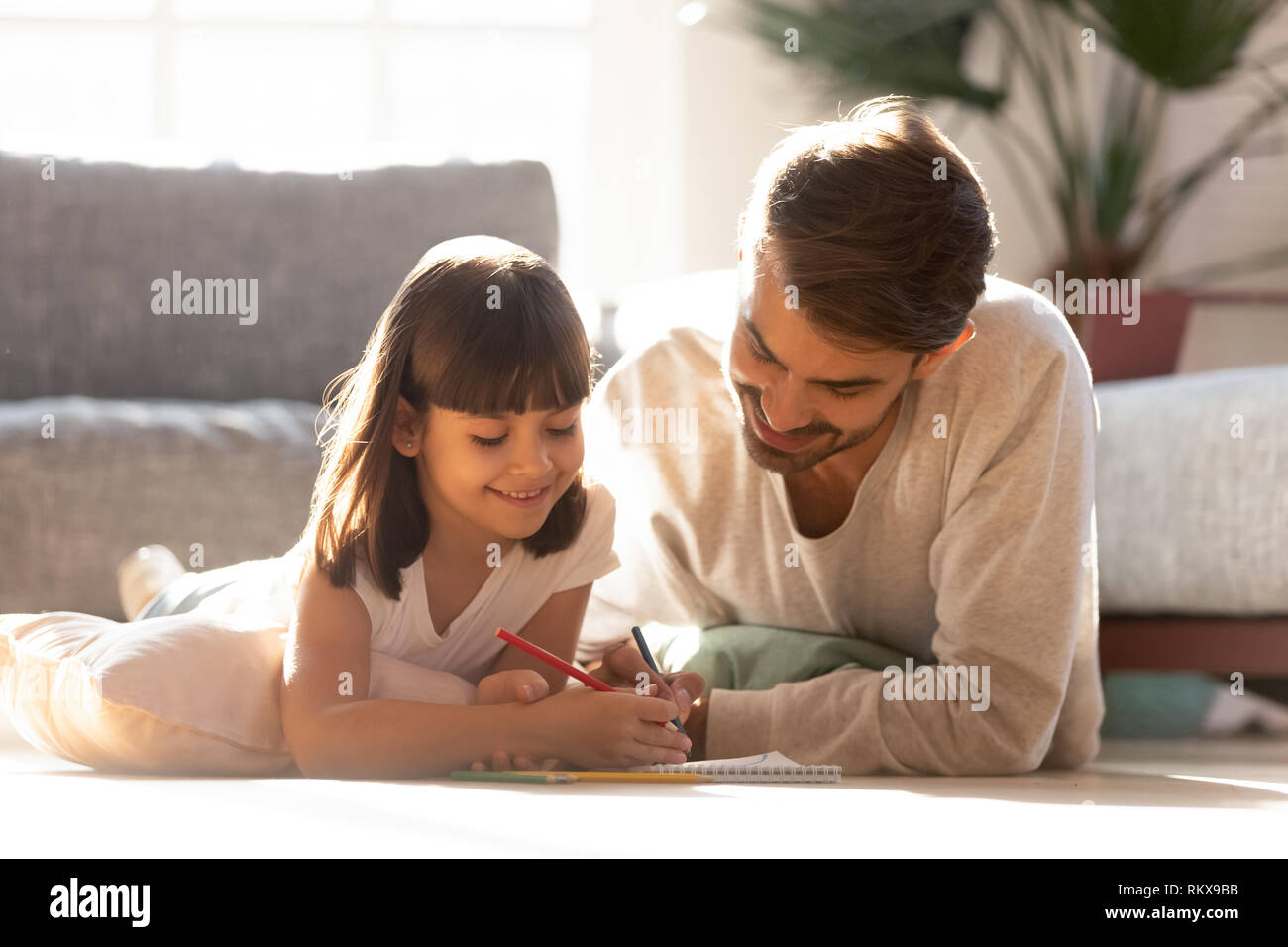Caring dad and kid daughter enjoy drawing with colored pencils Stock ...