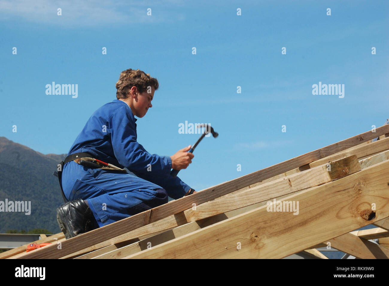 builder driving home a nail while finishing the roof framing Stock ...