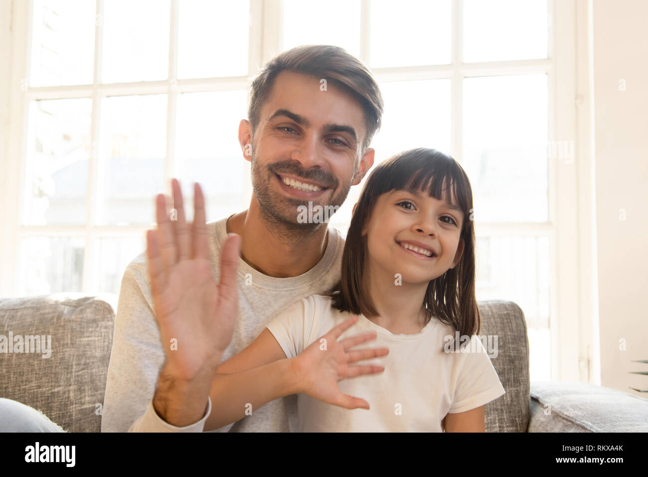 Happy child girl and father wave hands record vlog Stock Photo - Alamy