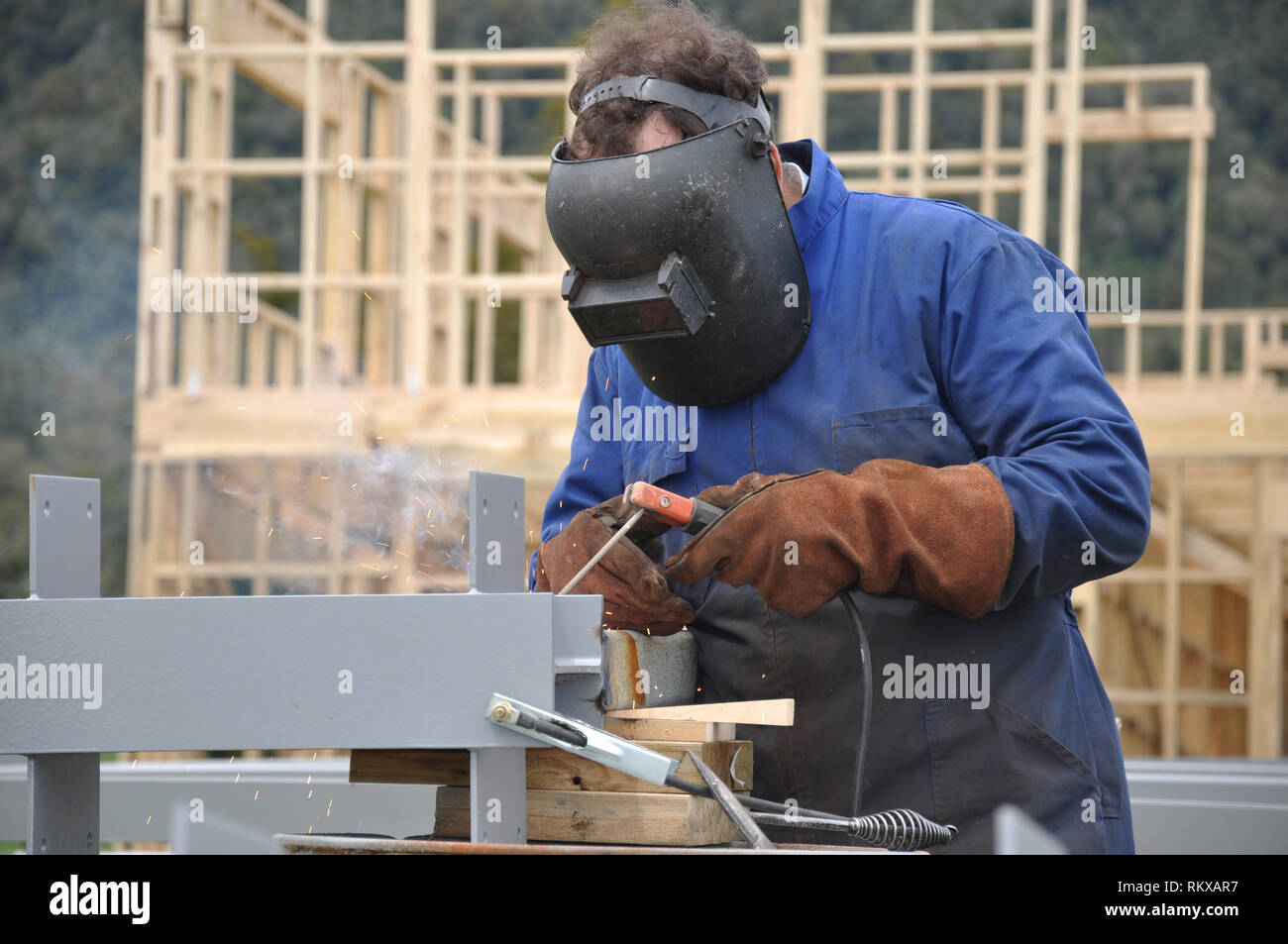 A welder prepares steel beams for a building at a construction site ...