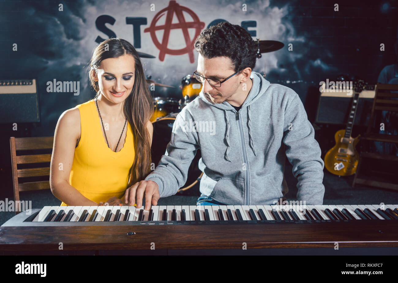 Piano teacher giving lessons to his student in music school Stock Photo ...